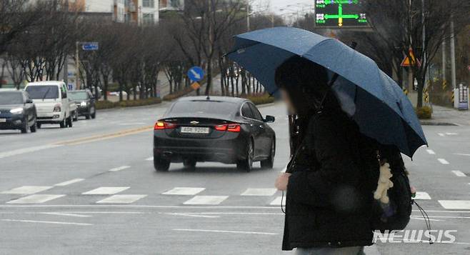 연이어 내리는 봄비에 우산 들고 길 지나는 시민