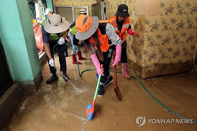 빗물에 잠겼던 주방 청소하는 자원봉사자들